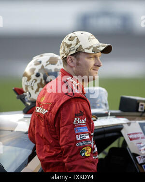 Dale Earnhardt Jr. stands near as his crew works on his car in the ...