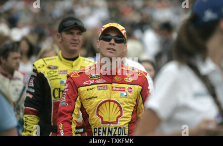 Kevin Harvick walks down pit road under an umbrella during a rain delay ...