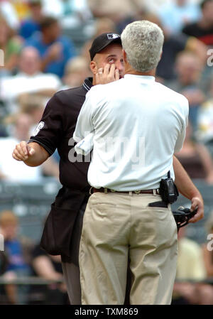 A Toronto Blue Jays staff member wearing gloves and a mask looks on ...