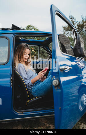 Woman using smartphone inside a car Stock Photo - Alamy