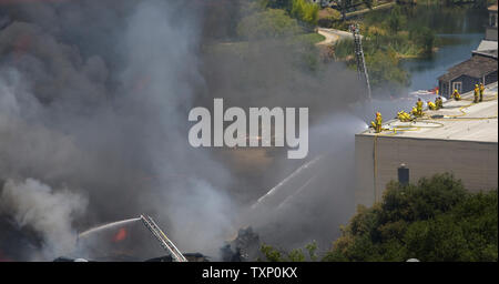Firefighters try to extinguish the final flames of a fire that ...