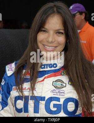 Race driver Milka Duno of Venezuela dons her helmet as she prepares to ...