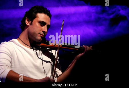 Arian plays guitar near the Milad tower in Tehran on October 2, 2005 ...