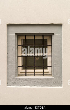 Window with iron grating on white wall. Lattice on the window ...