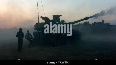 Israeli soldiers load shells in their tank following the first death on ...
