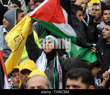 Palestinians hold yellow Fatah flags during the march for the 60th ...