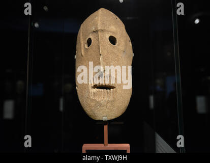 A mask from the Neolithic period ( 9,000 years ago) is displayed in the ...