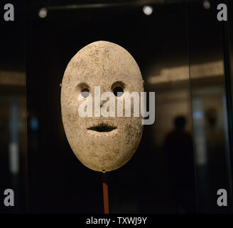 A mask from the Neolithic period ( 9,000 years ago) is displayed in the ...