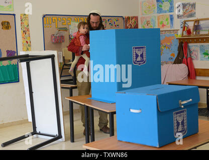 An Israeli settler votes in the West Bank settlement of Kiryat Arba ...