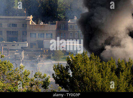 Firefighters on aerial ladders spray water on a fire as it rages out of ...