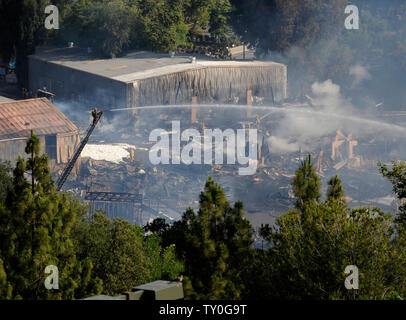Firefighters on aerial ladders spray water on a fire as it rages out of ...