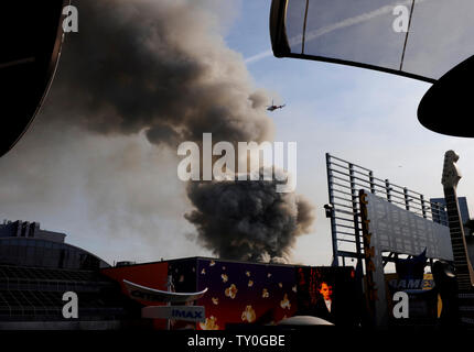 Smoke billows over Universal Walk as a fire rages out of control on the ...