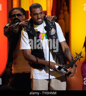 Kanye West (R) accepts the award for best male hip-hop artist with Lil ...