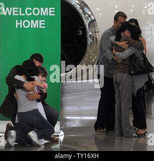 Laura Ling (L) is greeted by her mother Mary, father Michael, sister ...