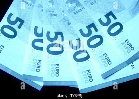 Fifty euro notes on a dark background close up. Blue color toned Stock ...