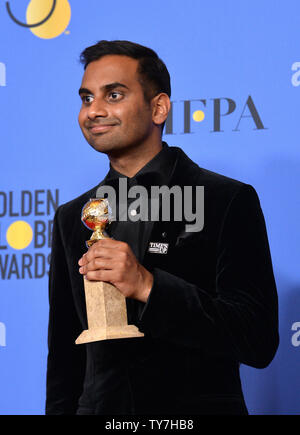 Actor Aziz Ansari (C) appears backstage after winning the award for ...