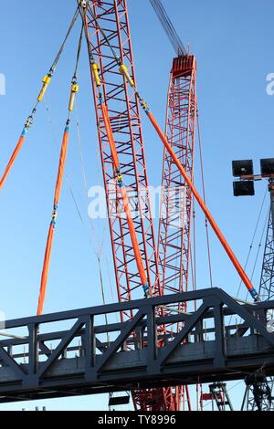 Sequence pictures of large crane lifting steel section of rail bridge ...
