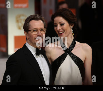 British actor Gary Oldman (R) and partner poses for the press at the ...