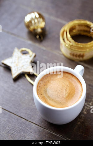 A cup of coffee and a small Christmas Star on wooden background. (focus ...