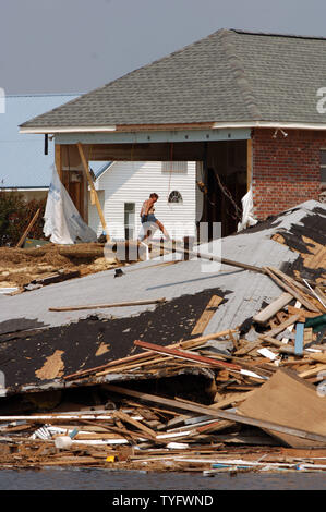 A woman surveys the damage in her home after it was struck by a rocket ...
