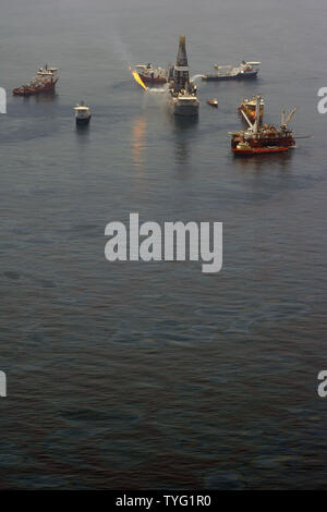 The Transocean Discoverer Enterprise drill ship (with flare) collects ...