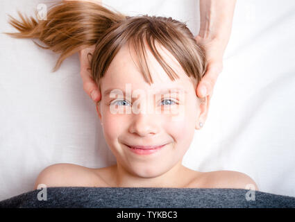 Elementary age girl receiving osteopathic or chiropractic treatment in ...