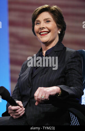 First Lady Laura Bush listens as President George W. Bush speaks at a ...