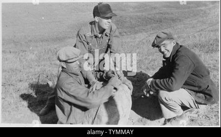 Three men try to move a boulder Stock Photo - Alamy