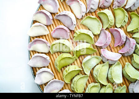 Multi-colored dumplings and white flour nearby Stock Photo - Alamy