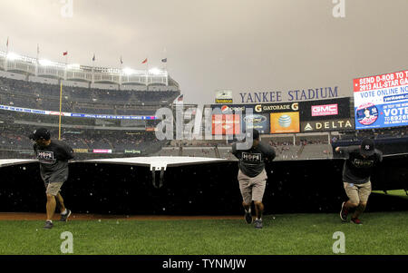 The New York Yankees ground crew prepares the field before a baseball ...