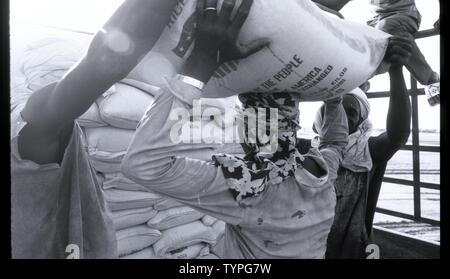 WOMAN CARRYING RICE BAG OVER HER HEAD Stock Photo - Alamy