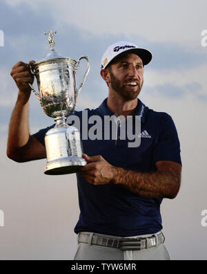 Dustin Johnson poses with his trophy on the 18th green after winning ...