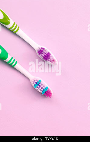 Two toothbrushes lie on a pastel pink background. Top view, flat lay ...
