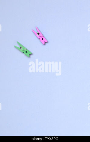 Two colored wooden pegs lie on texture background of fashion pastel ...
