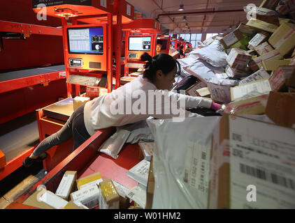 Workers sort through packages at STO Express's logistics center in Yiwu ...