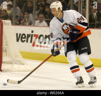New York Islanders' Radek Martinek, right, loses his helmet as he is ...