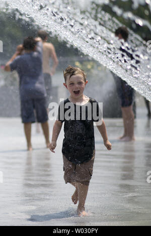 A boy cools off in the fountain, at Wenceslas Square, in Prague, on ...