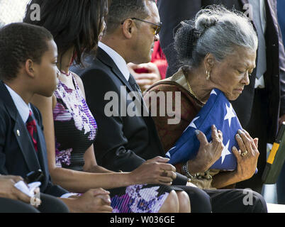 Nola Whitfield, wife of 2nd Lt. Malvin G. Whitfield, hugs the U.S. flag ...