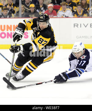 Winnipeg Jets center Adam Lowry (17), left, pressures St. Louis Blues ...