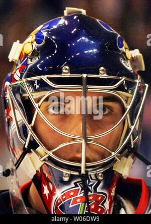 Columbus Blue Jackets' Pascal Leclaire, left, covers the puck as ...