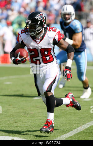 Atlanta Falcons running back Warrick Dunn runs past an upended ...