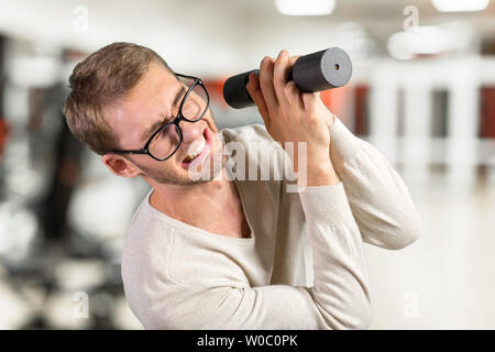 Funny weak body builder tries to exercise. Studio shot on white ...