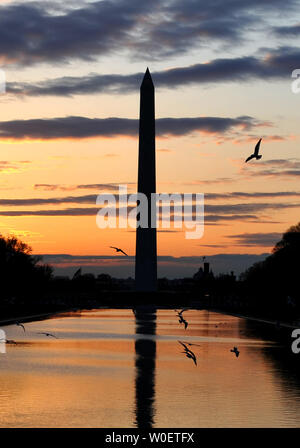 The sun rises near the Washington Monument Wednesday, July 1, 2026, in ...