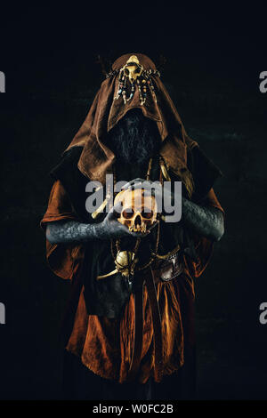 Portrait of a shaman holding a human skull in his hands Stock Photo - Alamy