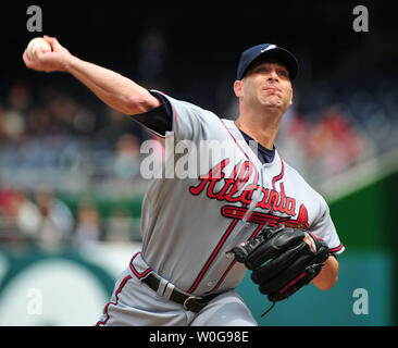 Atlanta Braves pitcher Tim Hudson uses a rosin bag to powder his head ...