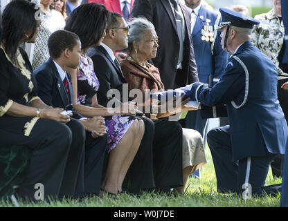 Nola Whitfield, wife of 2nd Lt. Malvin G. Whitfield, hugs the U.S. flag ...