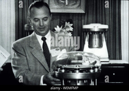 Ray Kroc, founder of McDonald's, is shown holding a hamburger in front ...