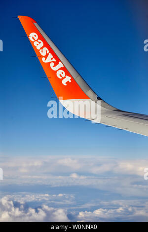 EasyJet logo Easy Jet logo on airplane wing, flying above clouds over ...