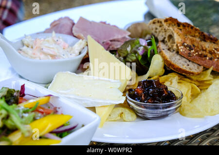 Ham and cheese ploughman's lunch on a wooden serving platter isolated ...