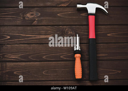 A closeup of red and grey hardware tools on wooden background. Vertical ...